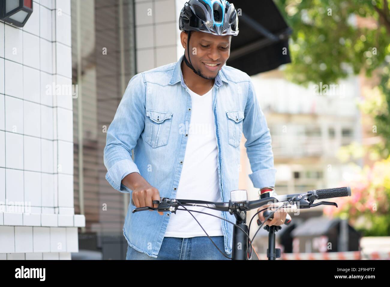 Man wearing a helmet while walking with a bicycle Stock Photo - Alamy