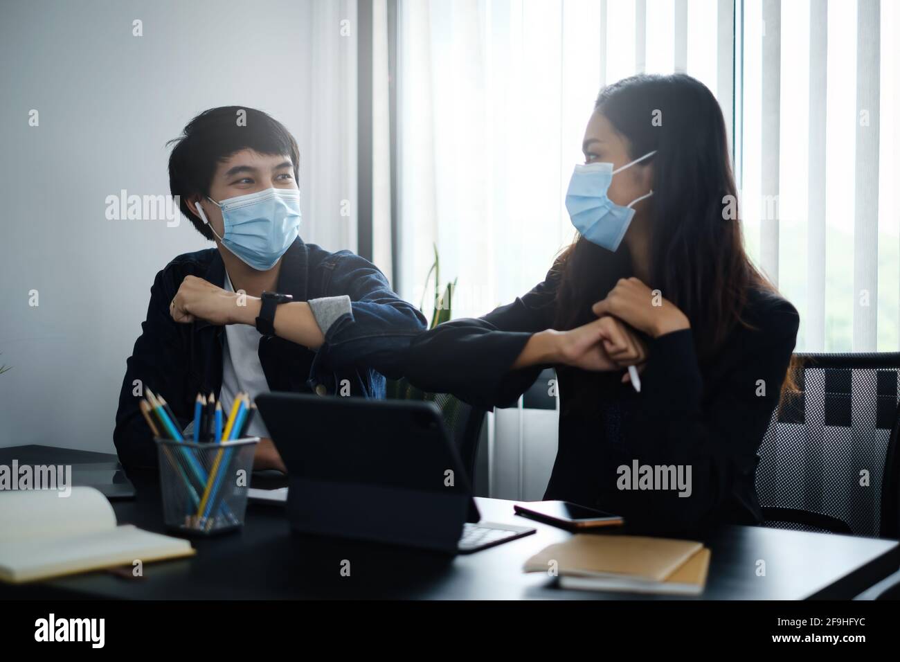 Business or accountant wear mask and bumping elbows for keeping social ...