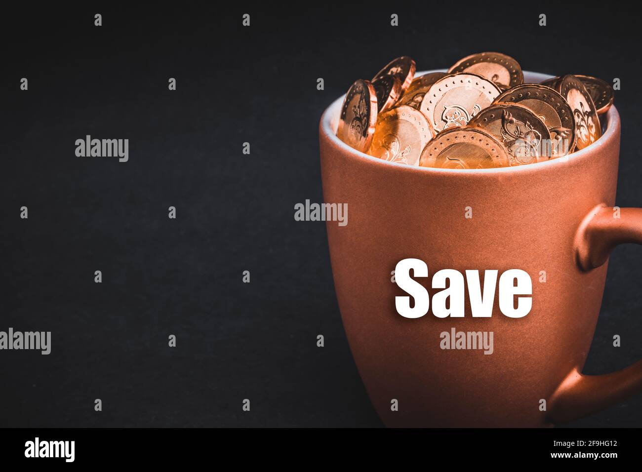 SAVE text with Coins in cups on black background. Tax, Savings, Profit ...