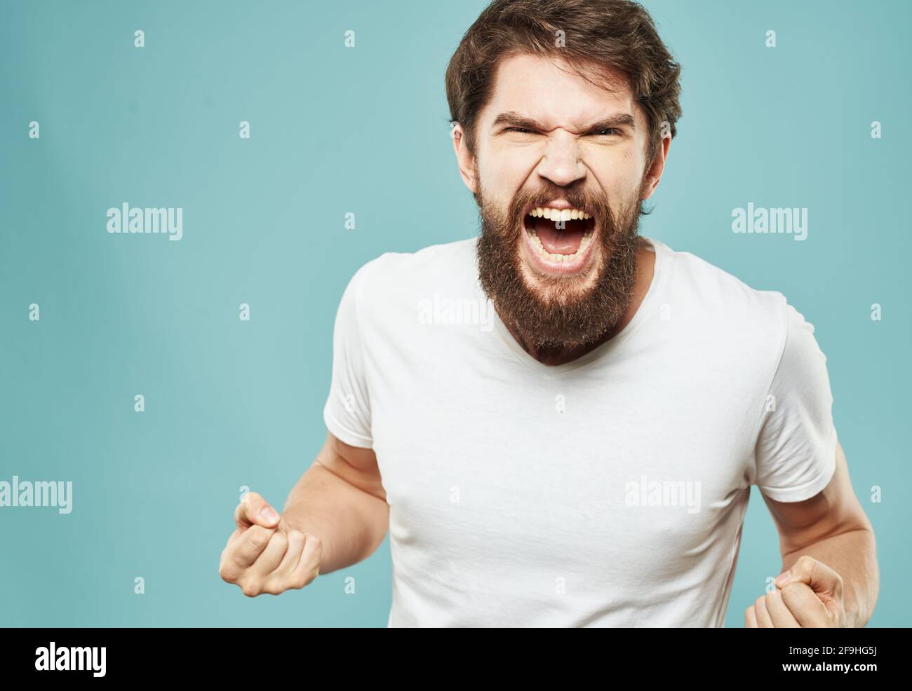 Aggressive man on blue background shows forefinger stress irritability ...