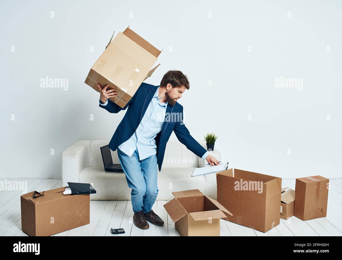 a man with a box of things unpacking a new place office lifestyle ...