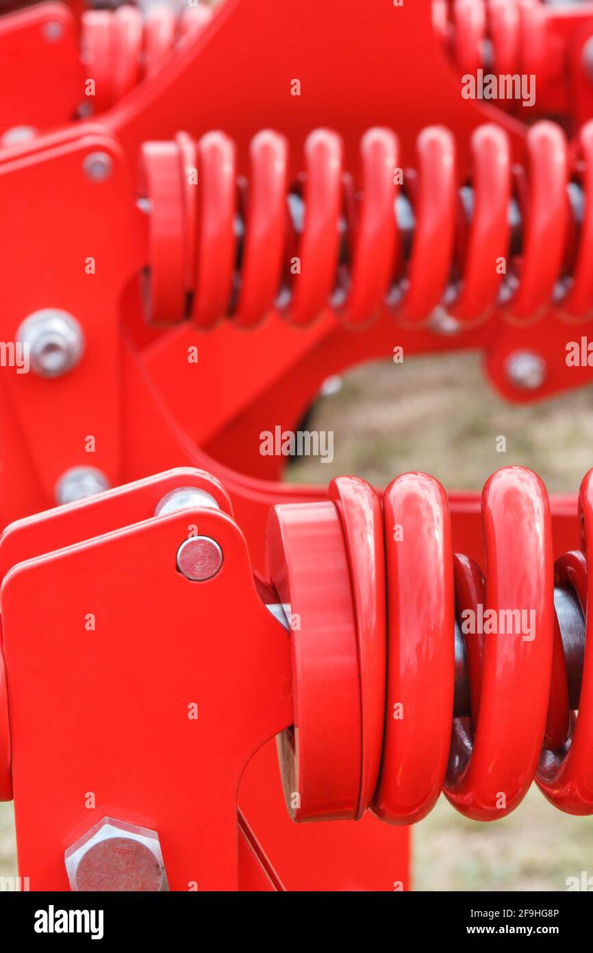 Hard red spring made of steel. Part of big industrial or agricultural ...