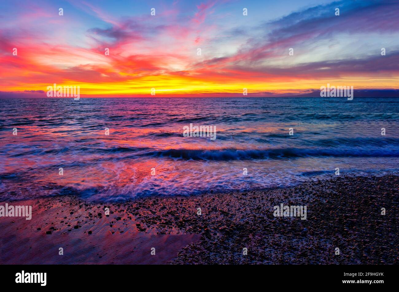 A Colorful Ocean Sunset Sky as a Gentle Wave Rolls to Shore Stock Photo ...
