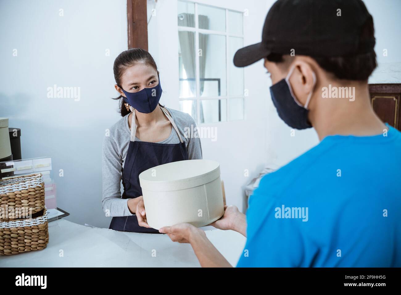 smiling young female shopkeeper receiving a package Stock Photo - Alamy