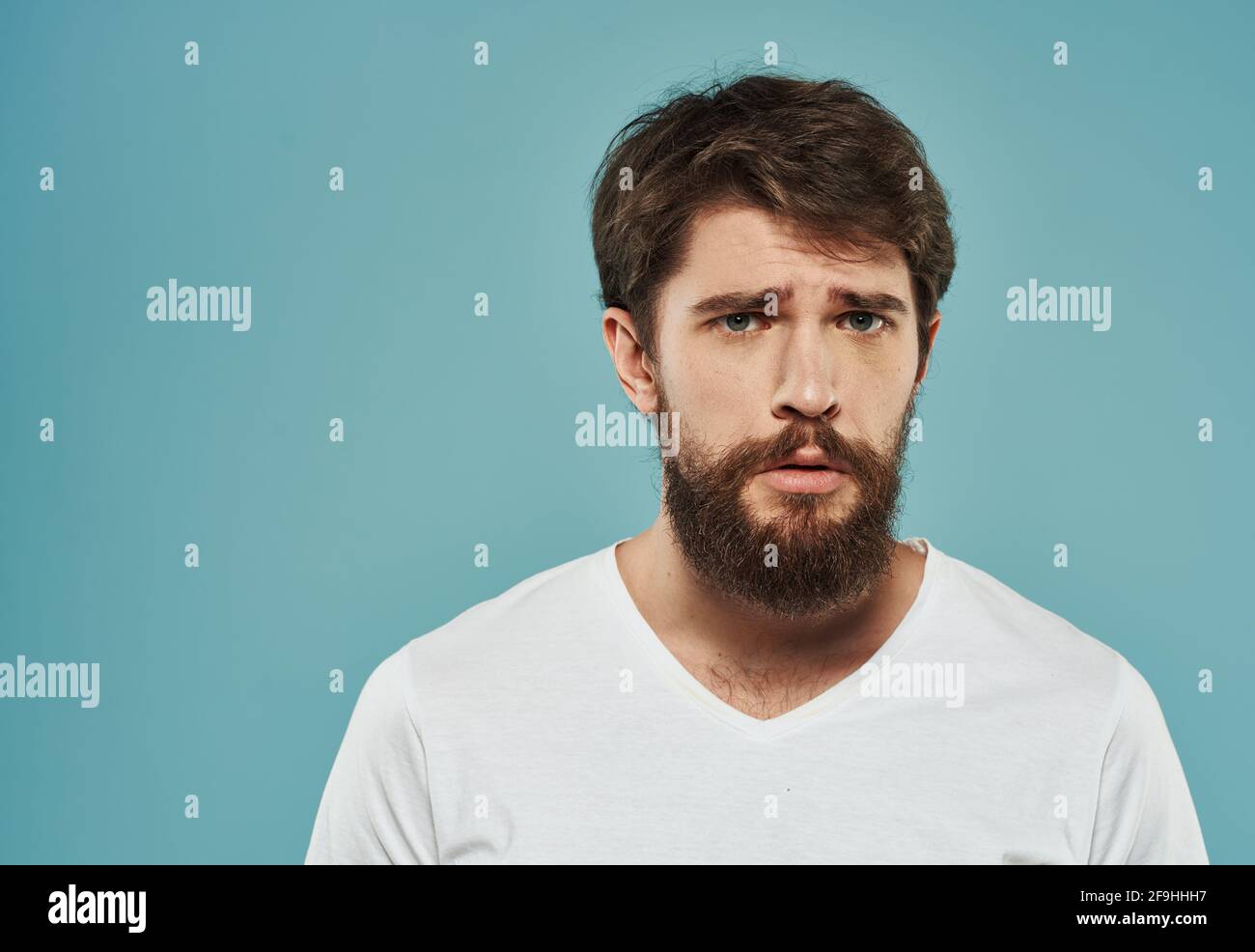 Portrait of a handsome man on a blue background with a cropped beard ...