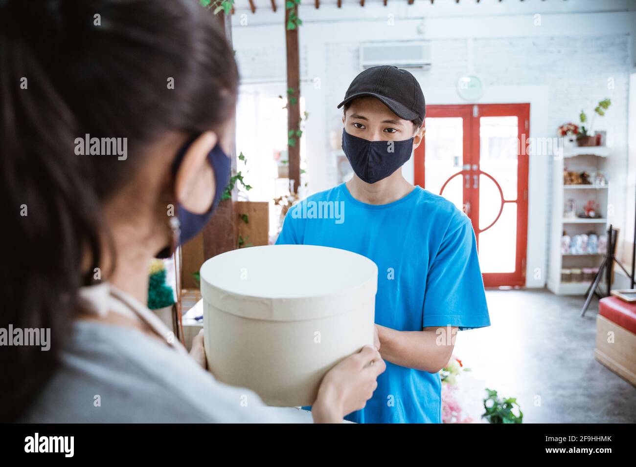 portrait smiling young female shopkeeper receiving a package Stock ...