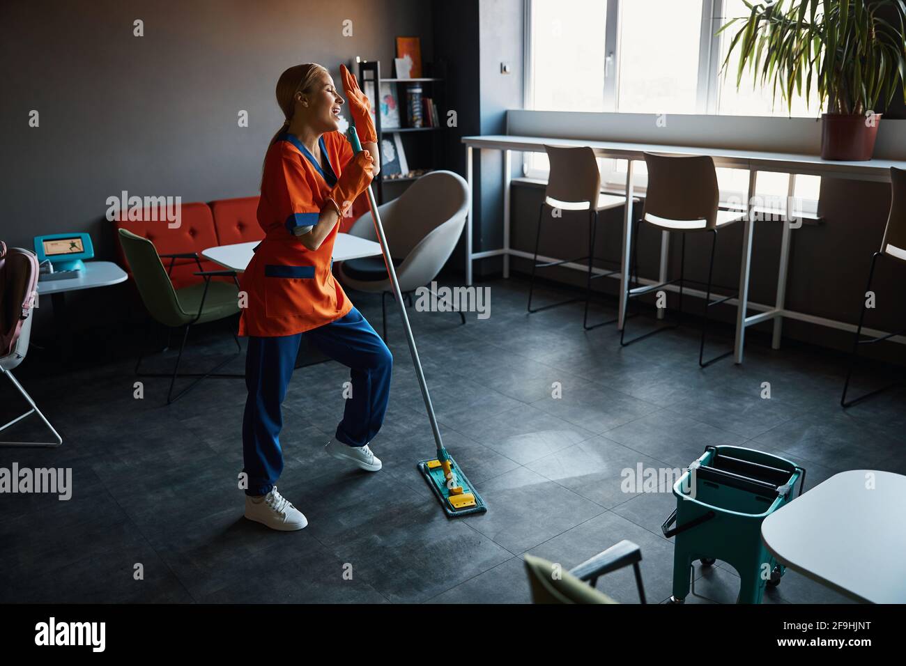 Female cleaner singing with her eyes closed during the clean-up Stock ...