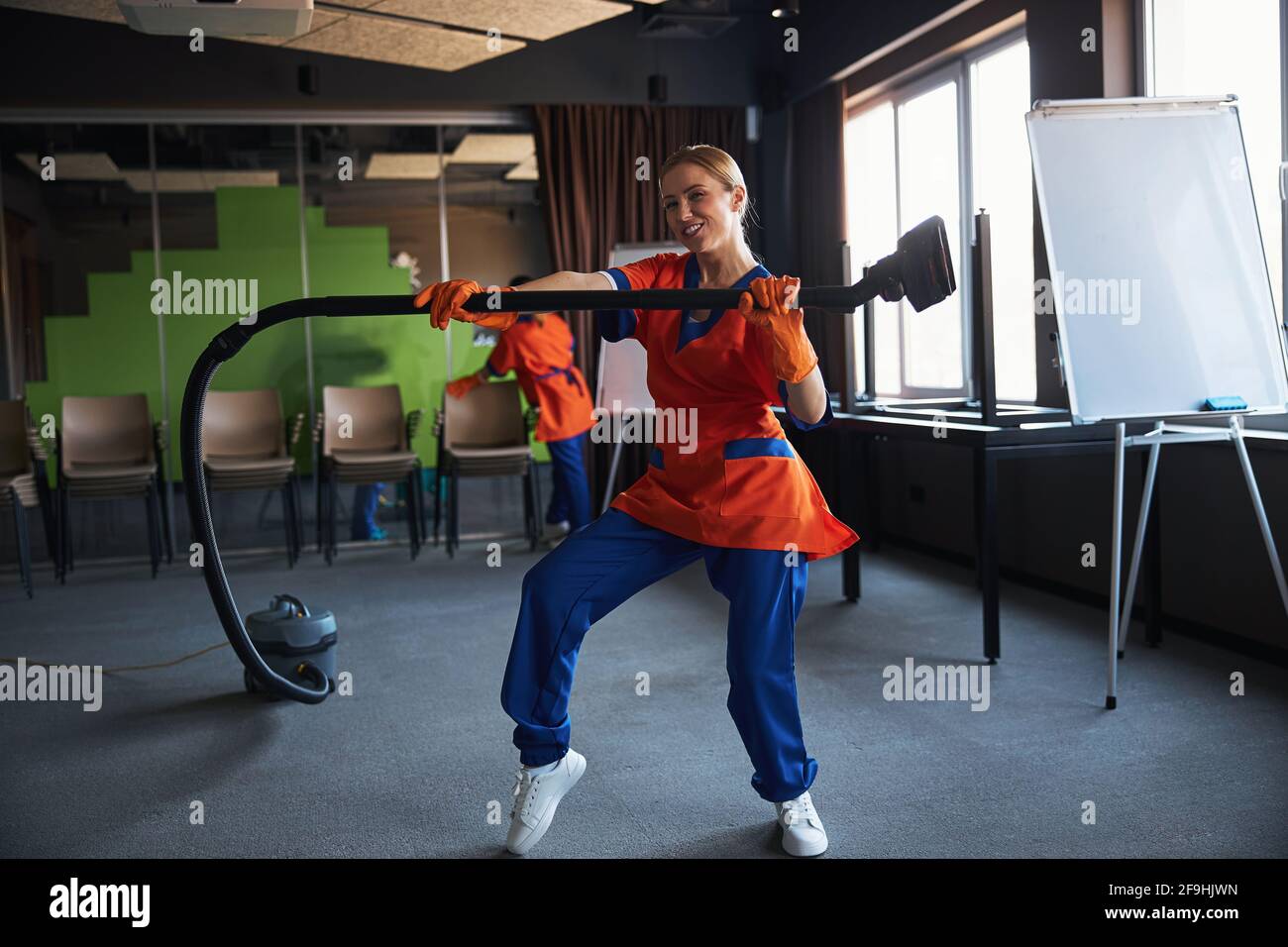 Cleaning lady standing in the conference hall during the clean-up Stock ...