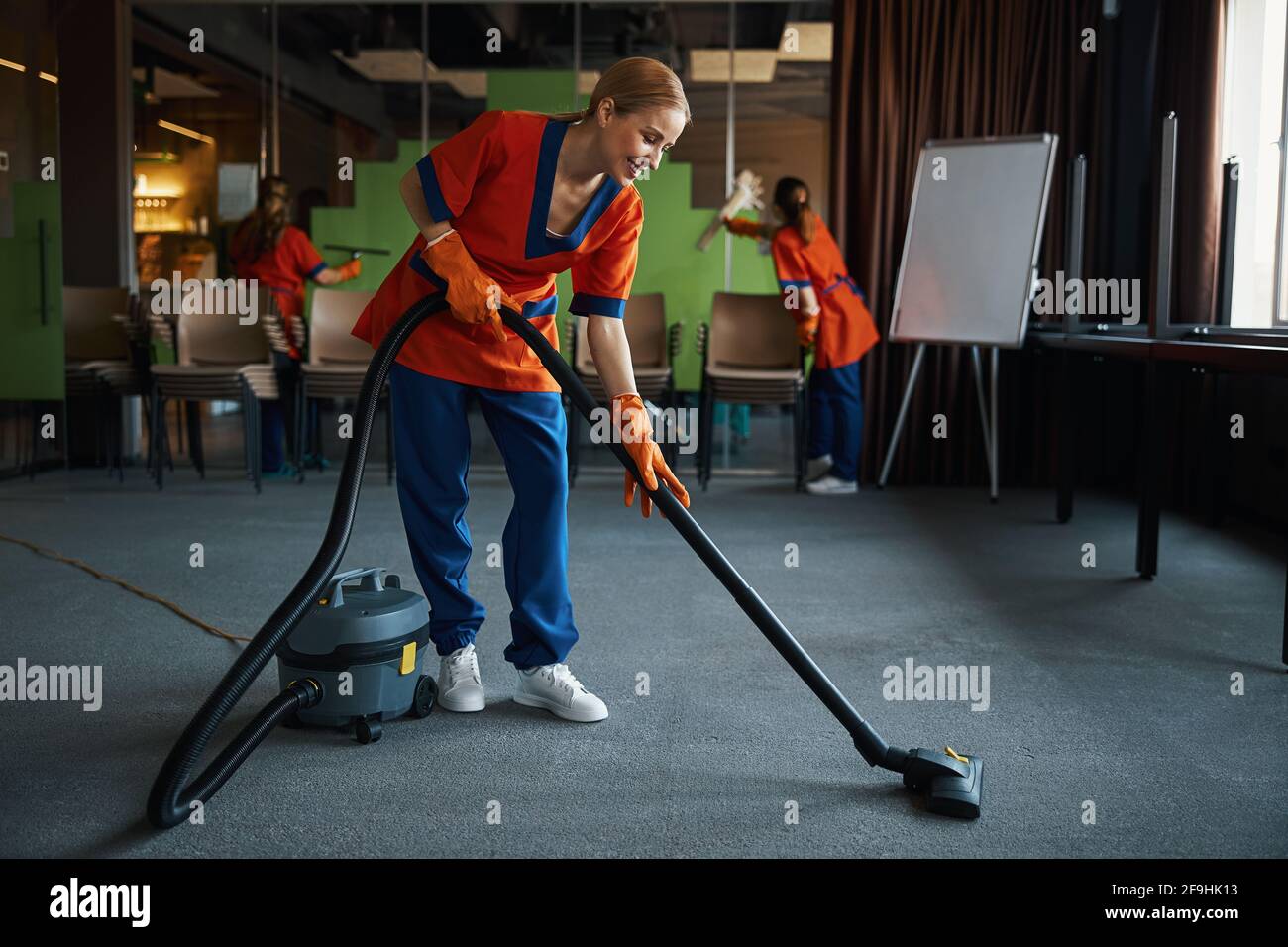 Janitorial staff tidying up the conference room Stock Photo - Alamy