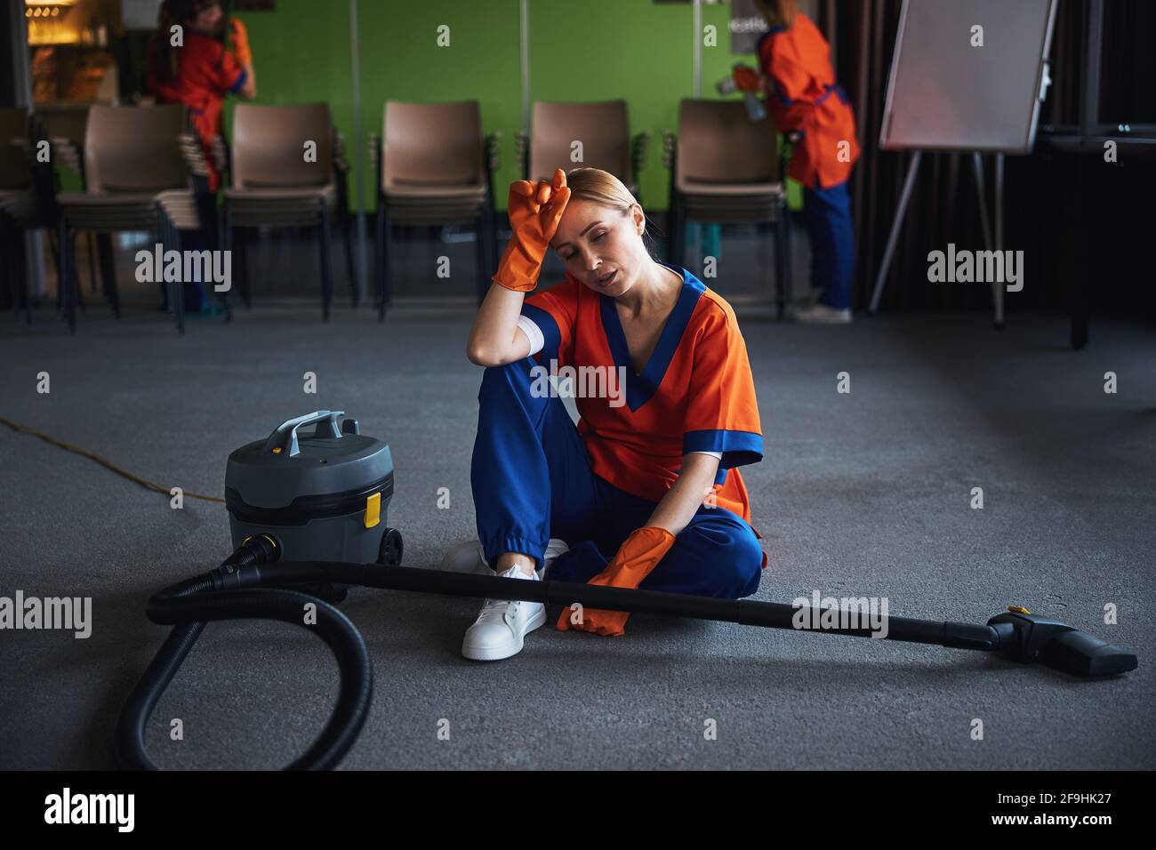 Exhausted cleaning lady resting after the vacuuming Stock Photo - Alamy