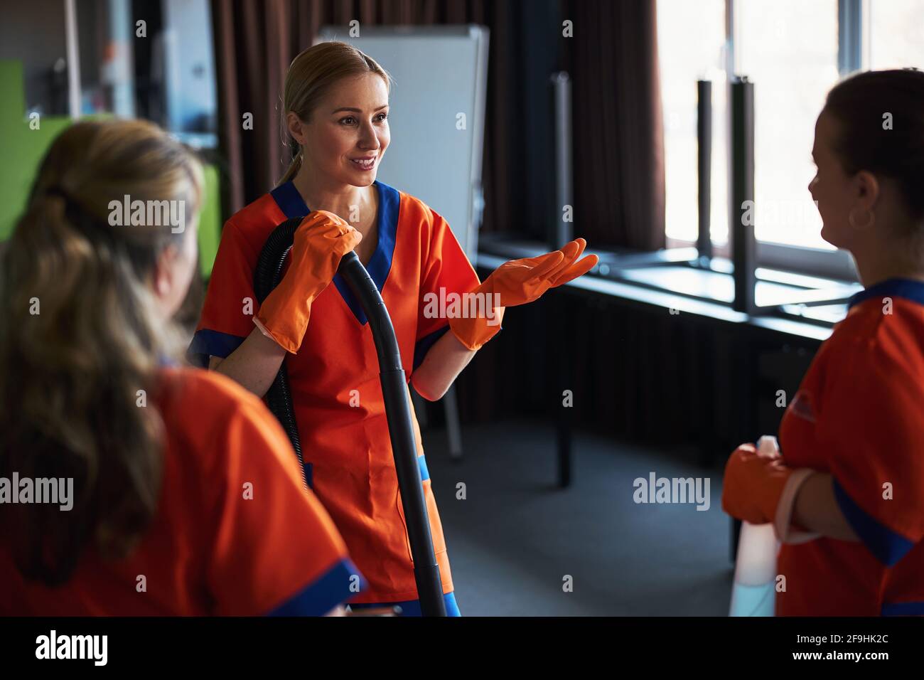 Female workers having a conversation during the office cleaning Stock ...
