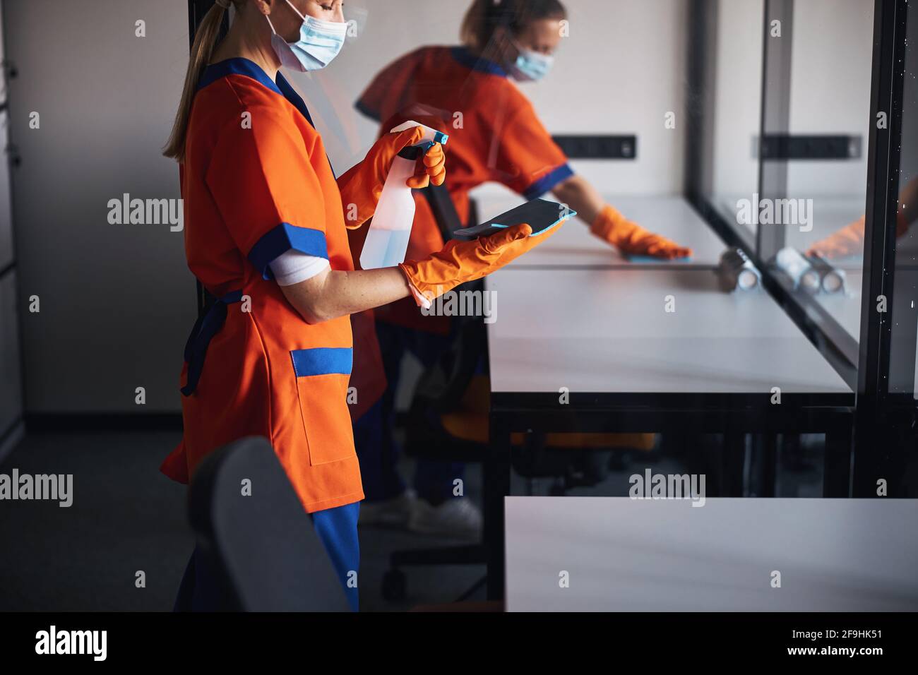 Two female workers in face masks doing the wet cleaning Stock Photo - Alamy