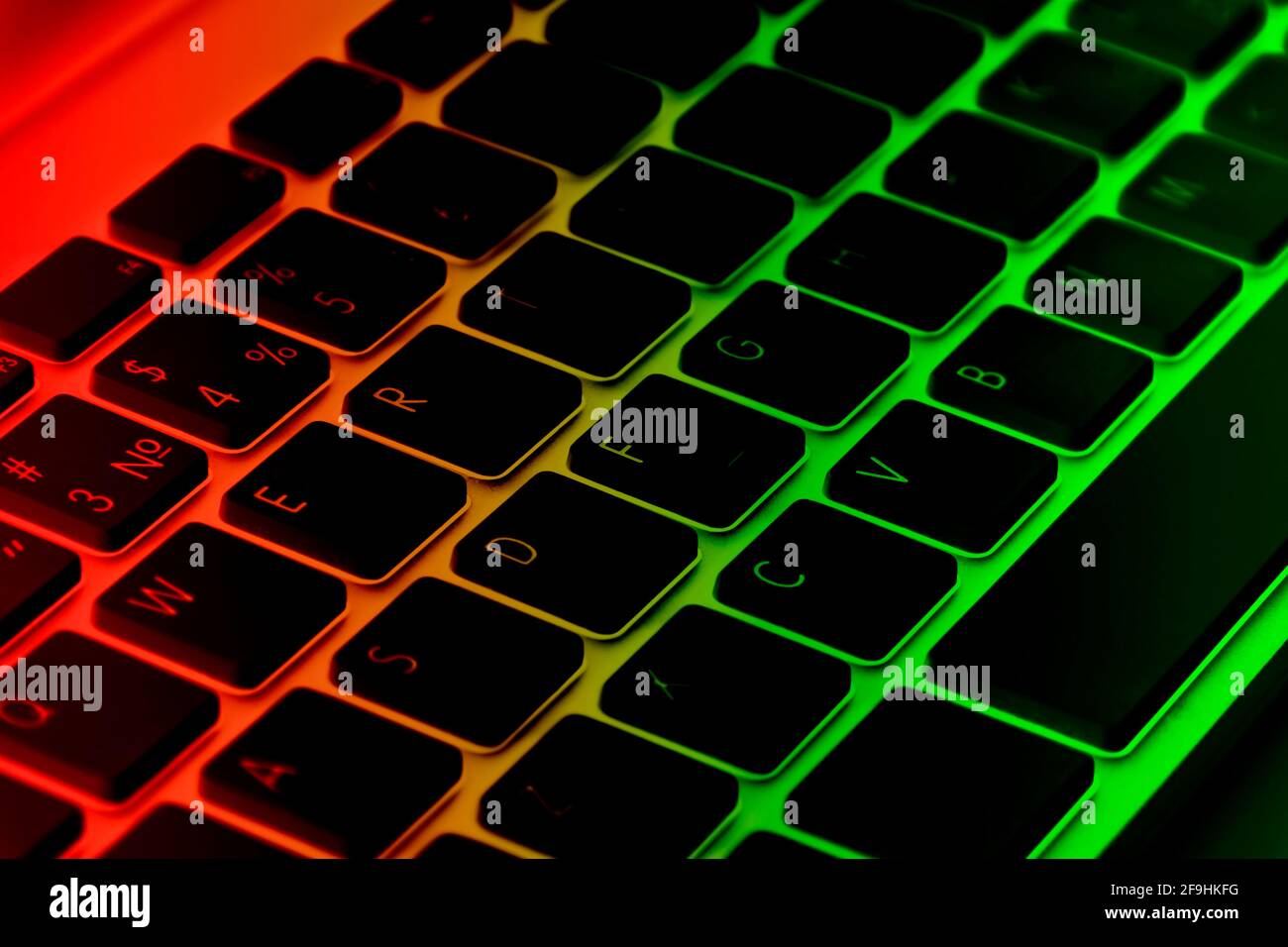 Close up view of a computer keyboard keys in red and green tones ...