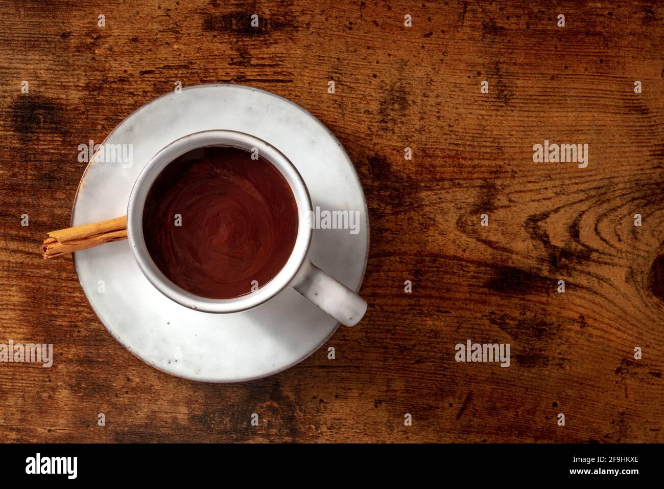 Hot chocolate cup, with a cinnamon stick, overhead shot with copyspace ...