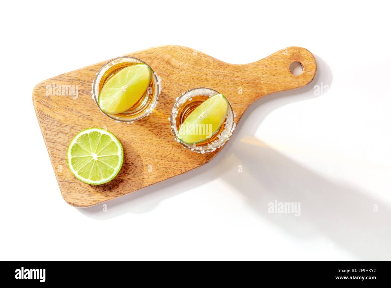 Tequila shots served on a wooden board with lime slices Stock Photo - Alamy