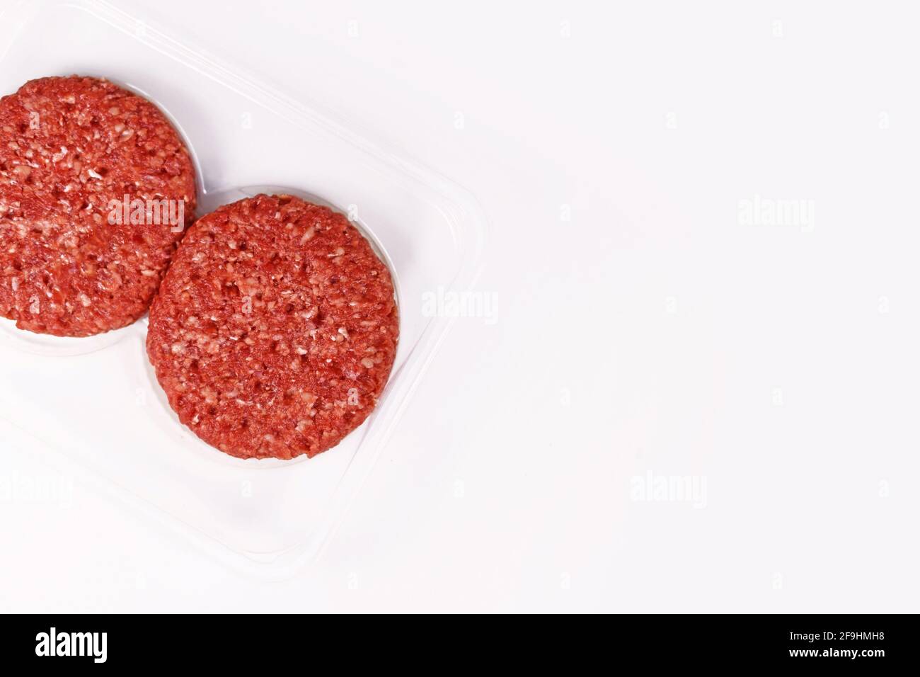 Raw round burger patties in package on white background with copy space ...
