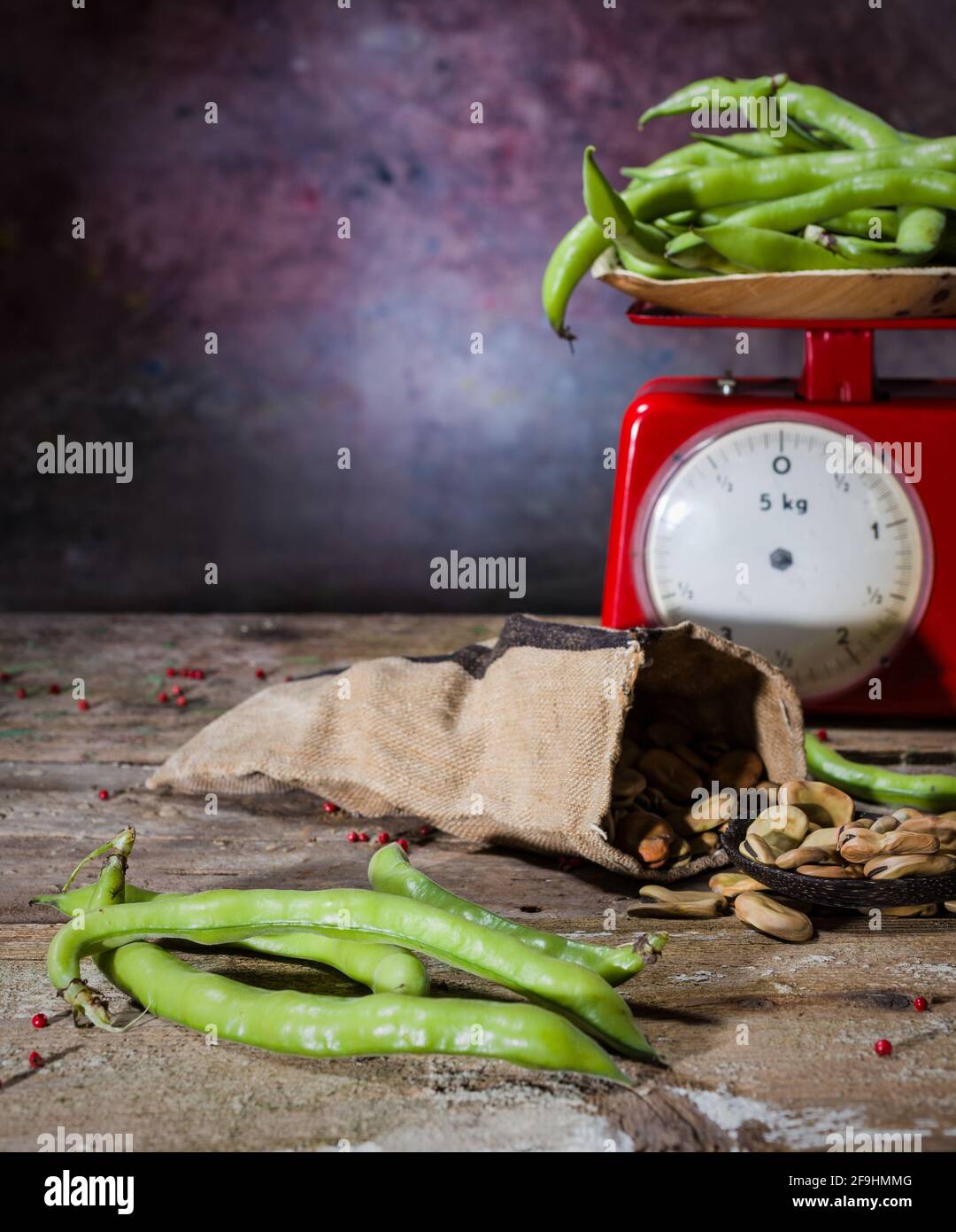 View of fresh and dried broad beans and weight scale in a wooden table ...
