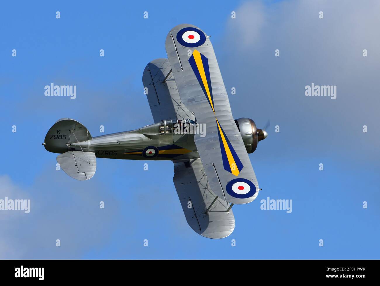 Vintage Gloster Gladiator aircraft in flight with cloud and blue sky ...