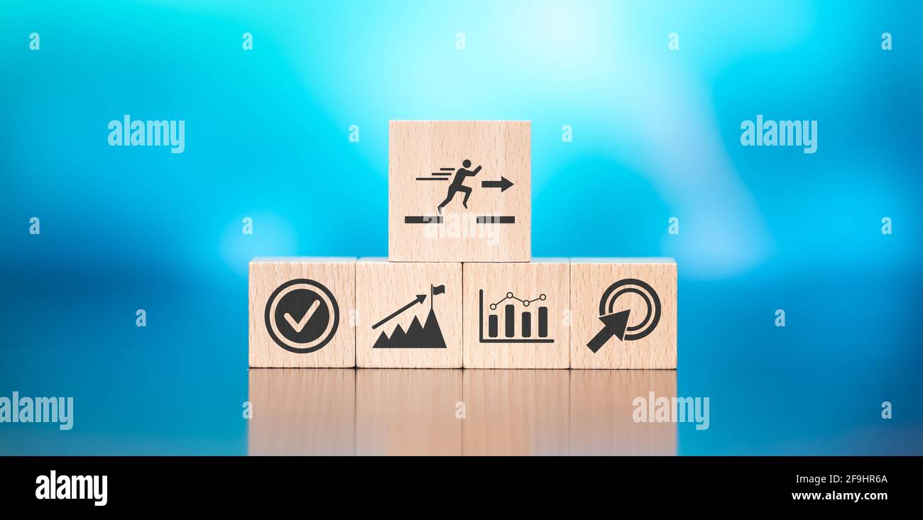 Wooden blocks with symbol of motivation concept on blue background ...