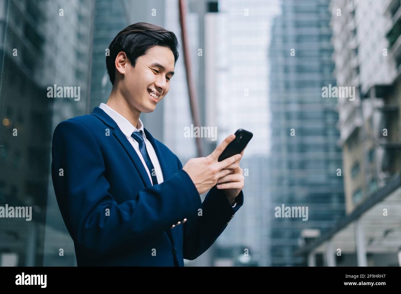Image of Young asian businessman with glass building background Stock ...