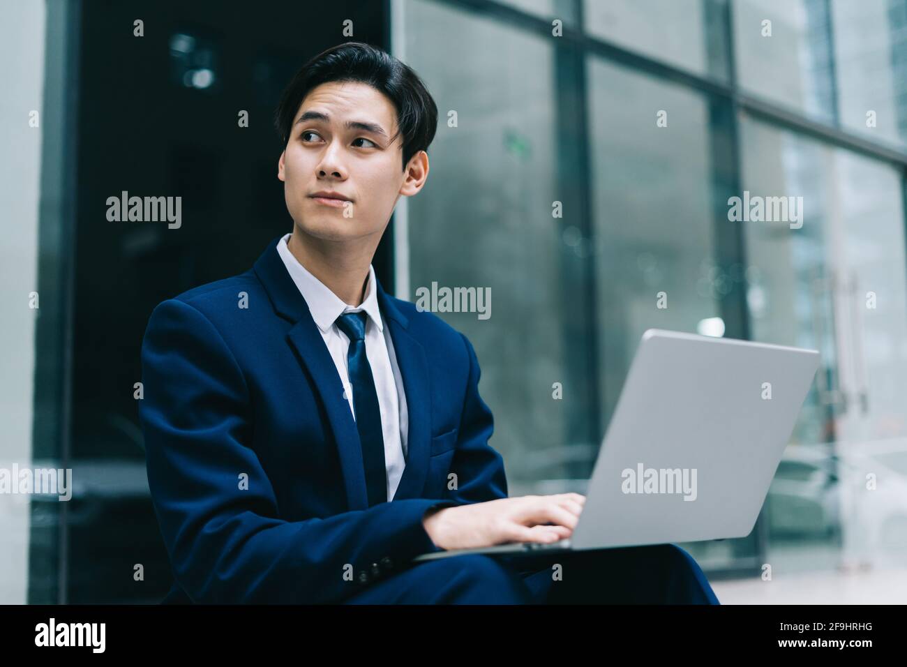 Image of Young asian businessman with glass building background Stock ...