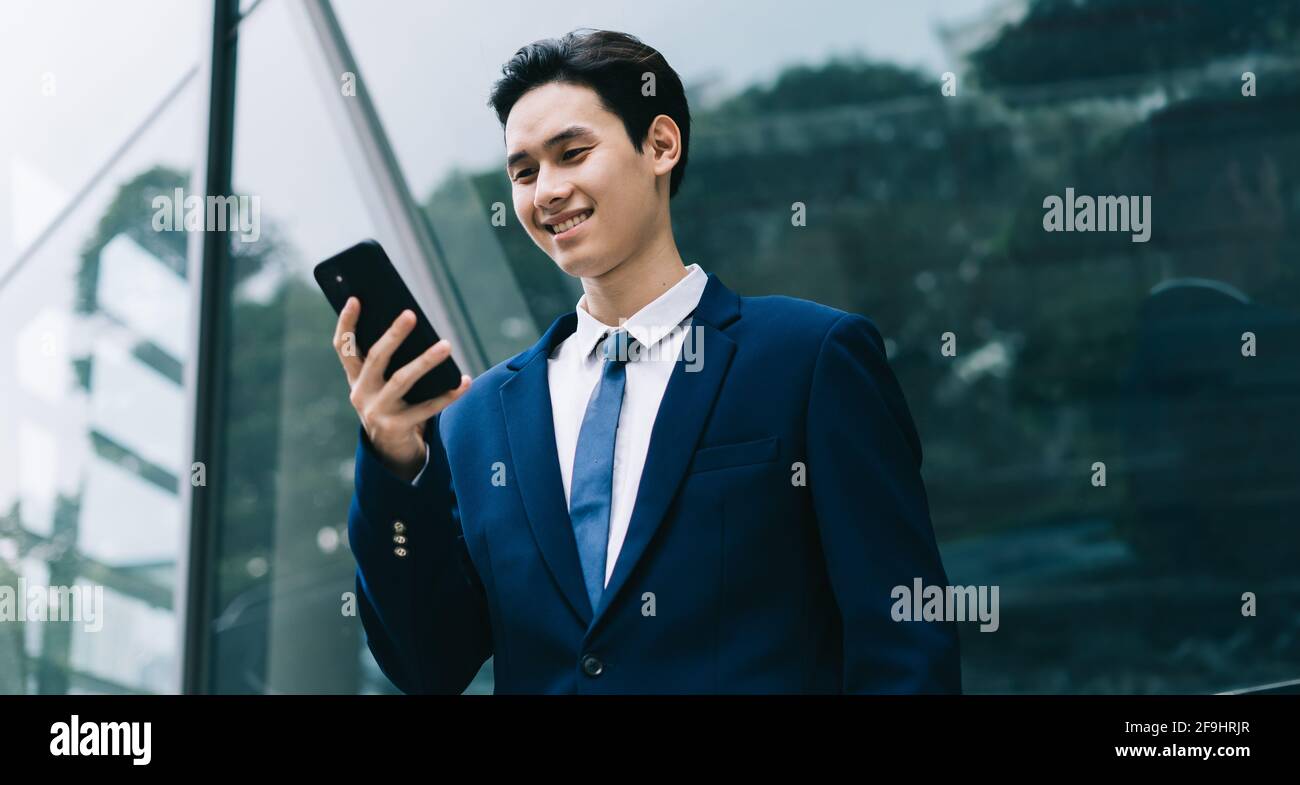 Image of Young asian businessman with glass building background Stock ...