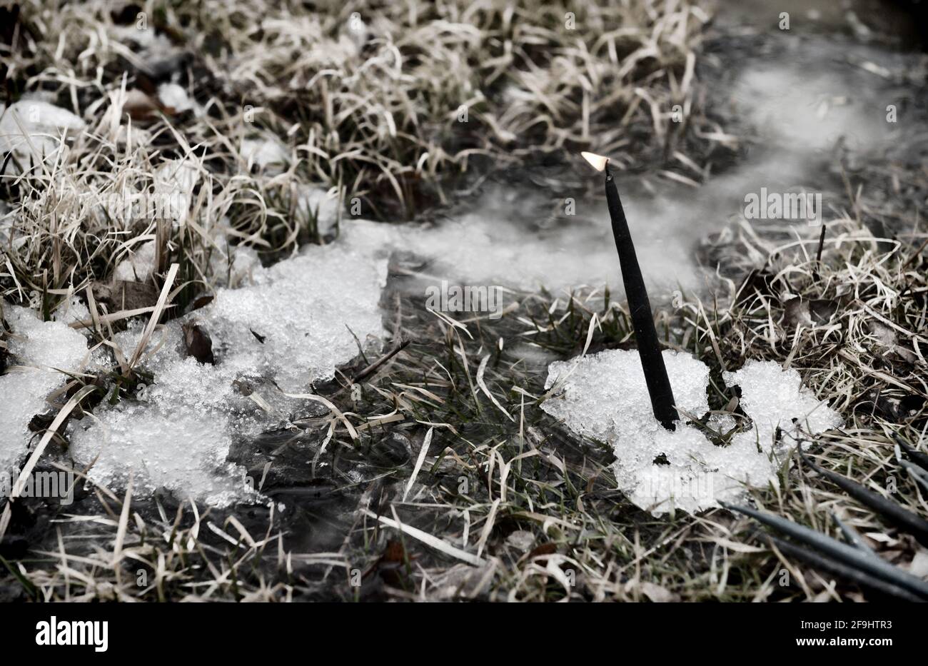 Burning black candle in snow outside in nature. Wiccan ritual with ...