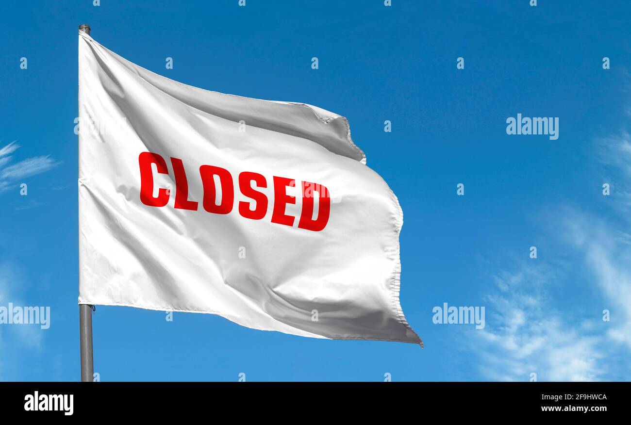 Closed - inscription by red letters on white flag against blue sky ...
