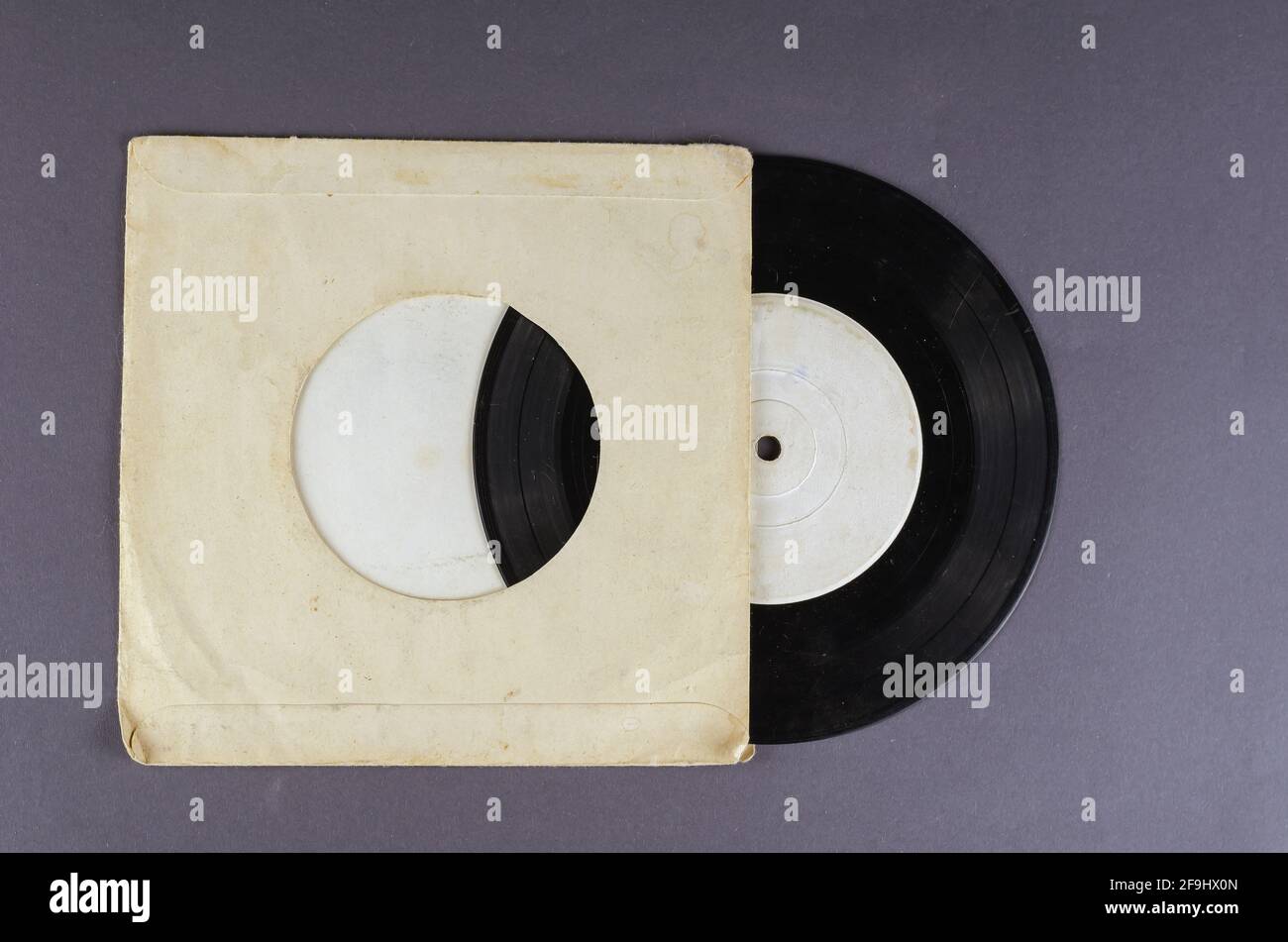Old paper wrapped vinyl record on gray background. Scuffed and ...