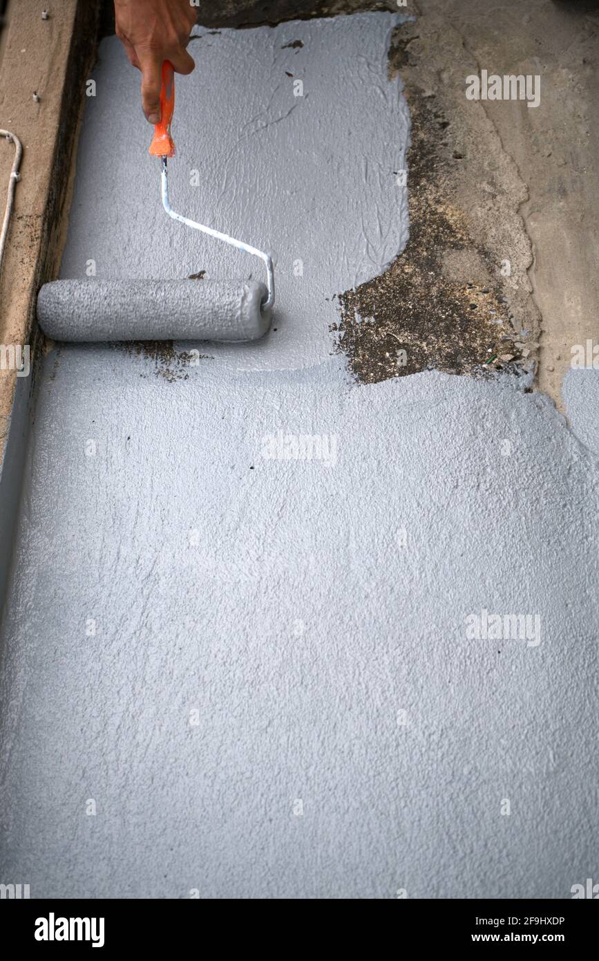 Worker with The roller brush, for waterproofing on the roof. House ...