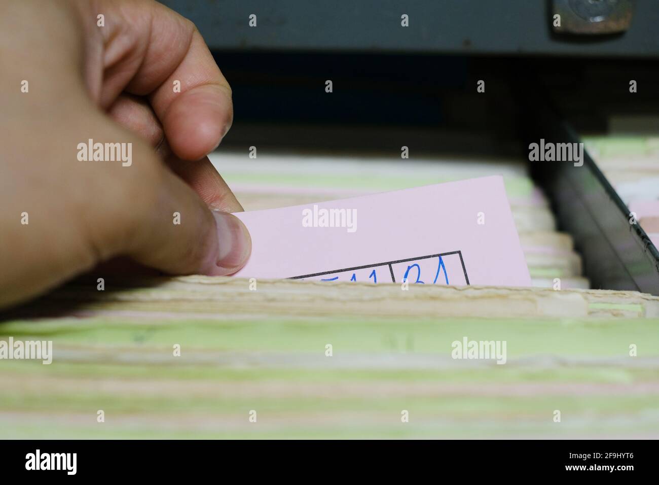 A closeup picture of a nurse's hand picking a paper medical record of a ...