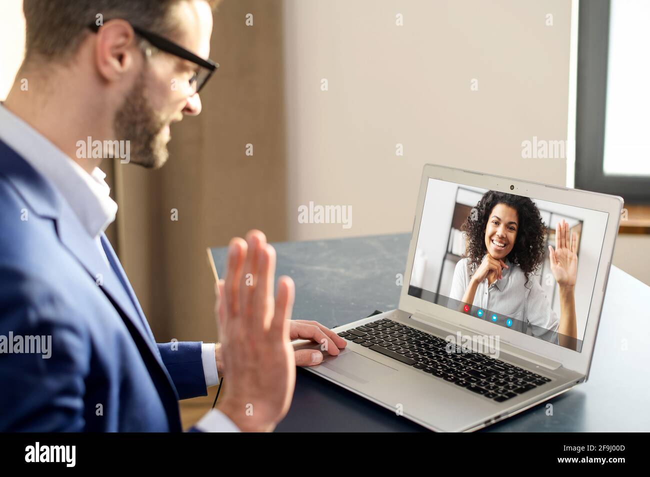 Side view of a business meeting online with a colleague using video ...
