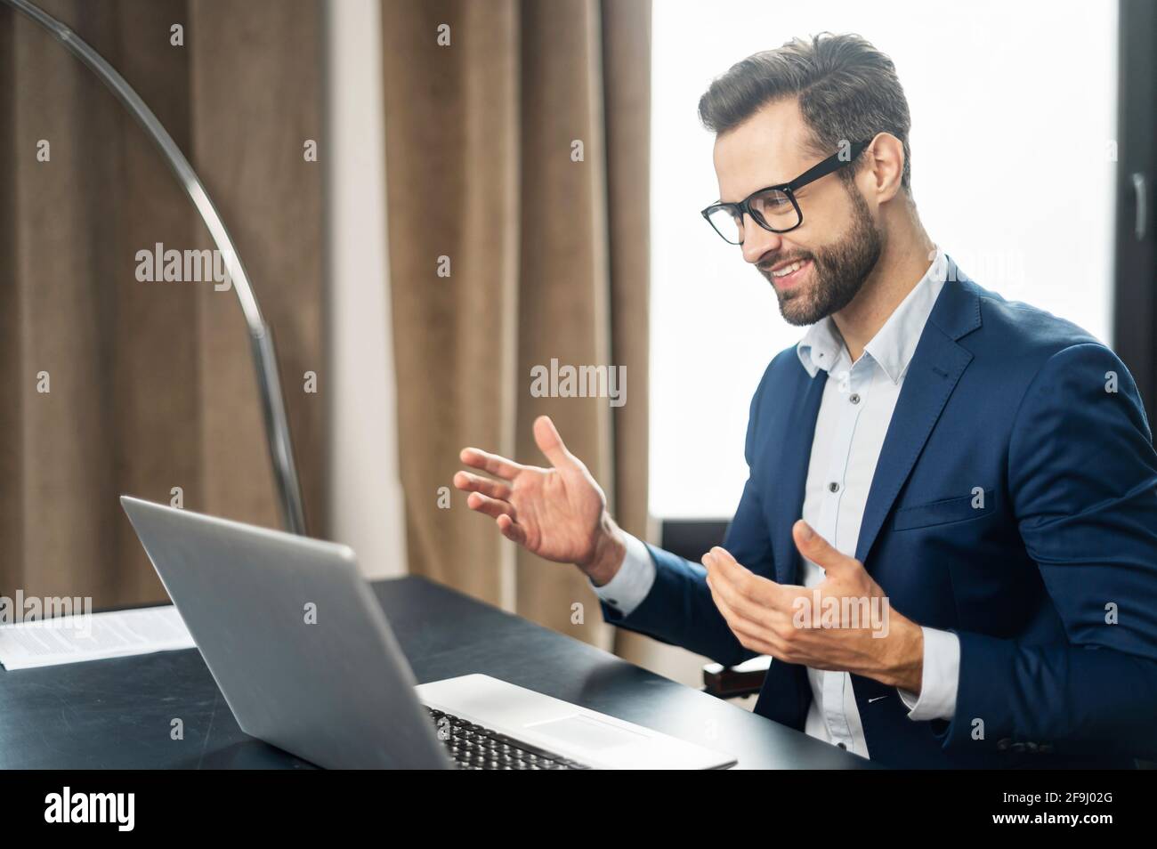 Slavic stylish man talking by video call, discussing work process ...