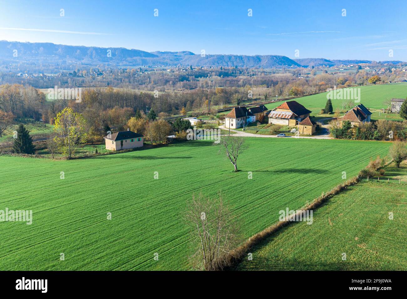Drone shot of houses of a small town located in the green farms of ...