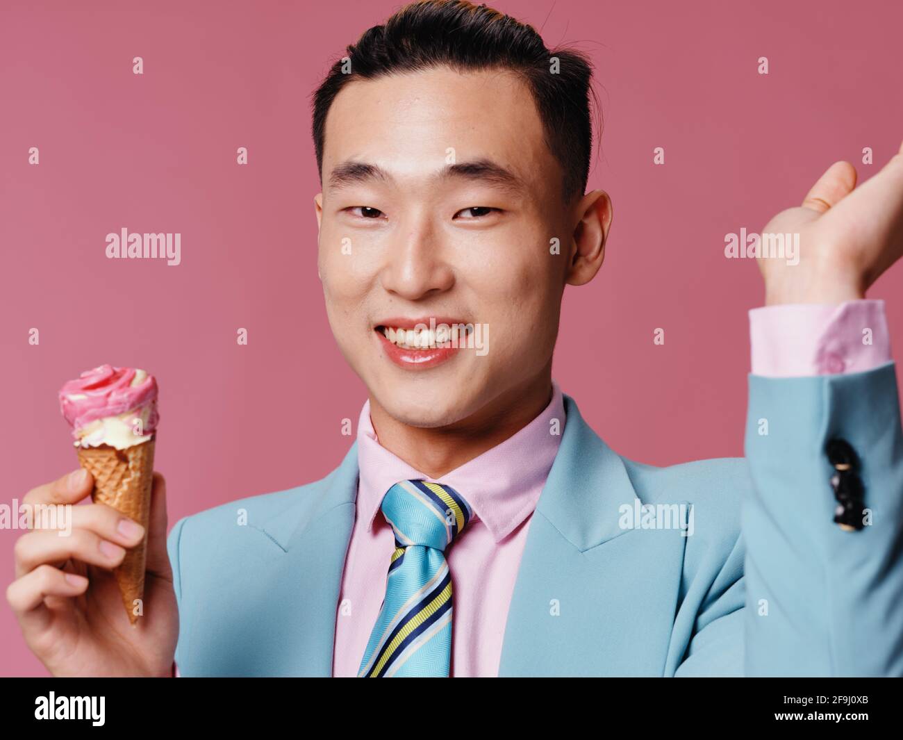 Man holding ice cream and jacket tie pattern pink background Stock ...