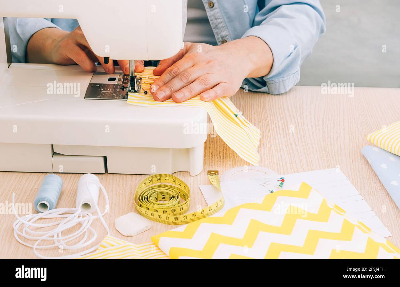 Women's hands sew a homemade medical mask during coronavirus pandemic ...