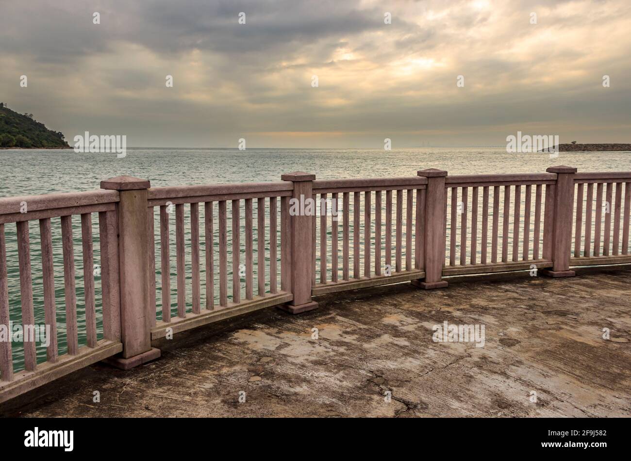 A small concrete platform with pink barrier by the sea. Both concrete ...