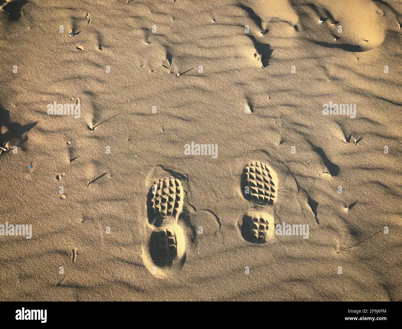 Overhead shot of shoe prints on the sand at a beach in Avola City ...