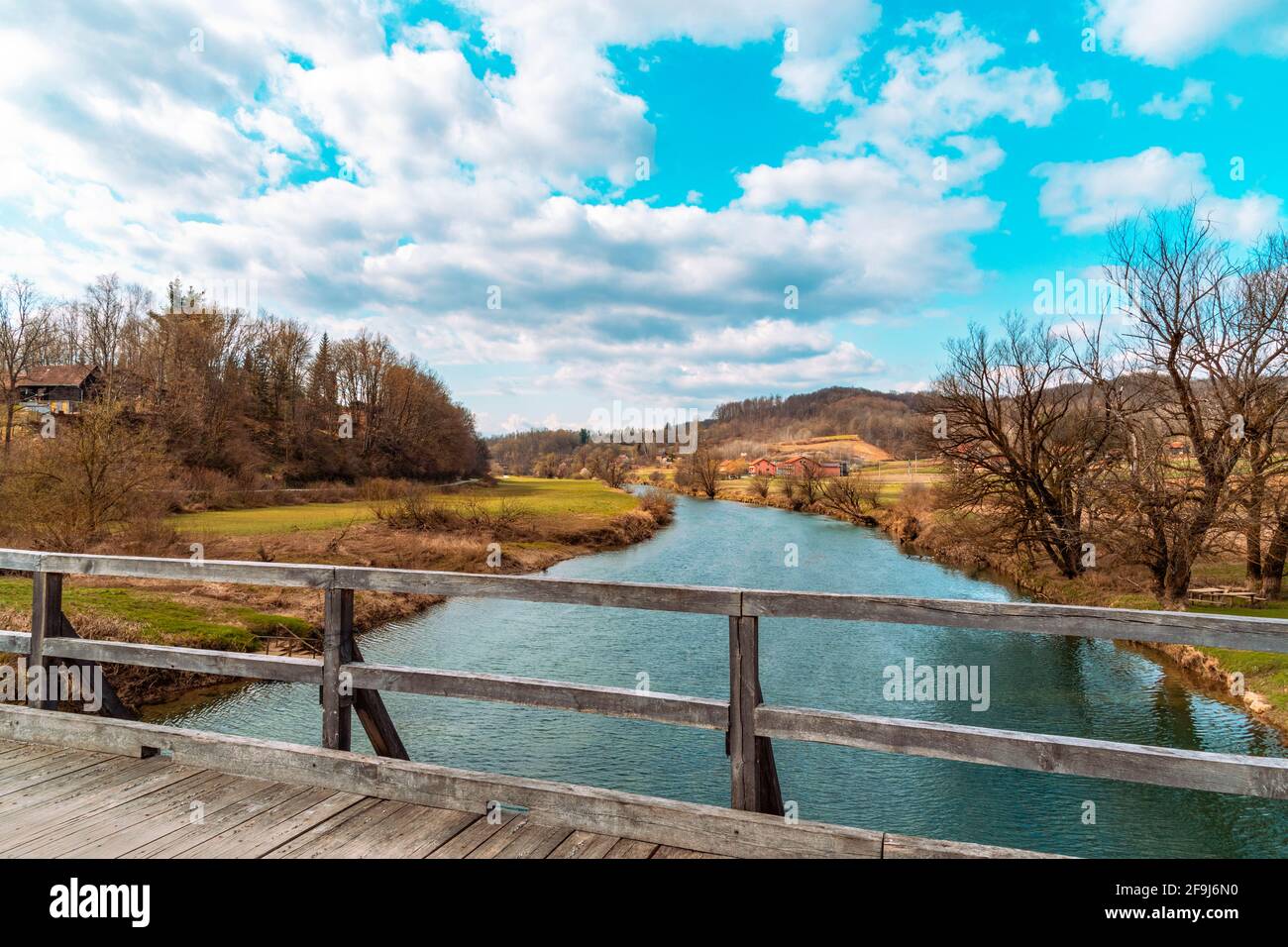 Rural landscape, wooden bridge and blue sky with clouds. Dobra river ...