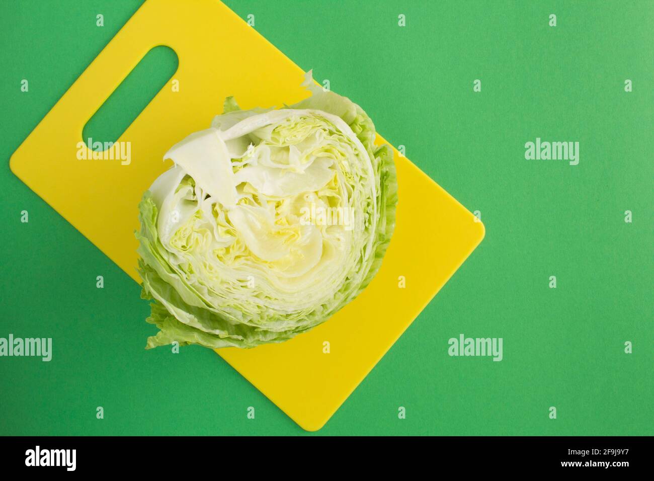 Sliced cabbage iceberg on a yellow cutting board on the green ...