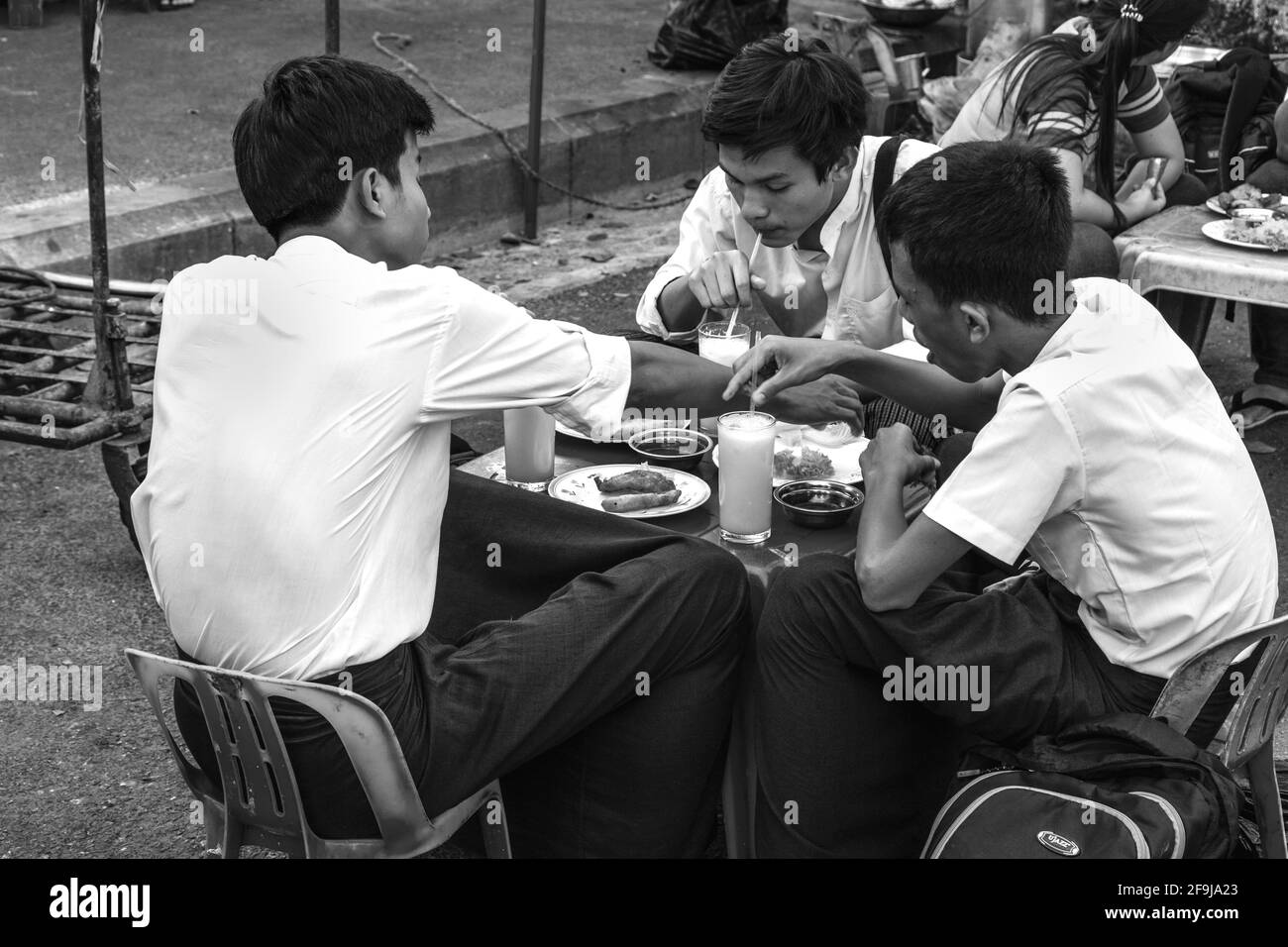 A Group Of Young People Eating A Meal At A Street Food Stall, Yangon ...
