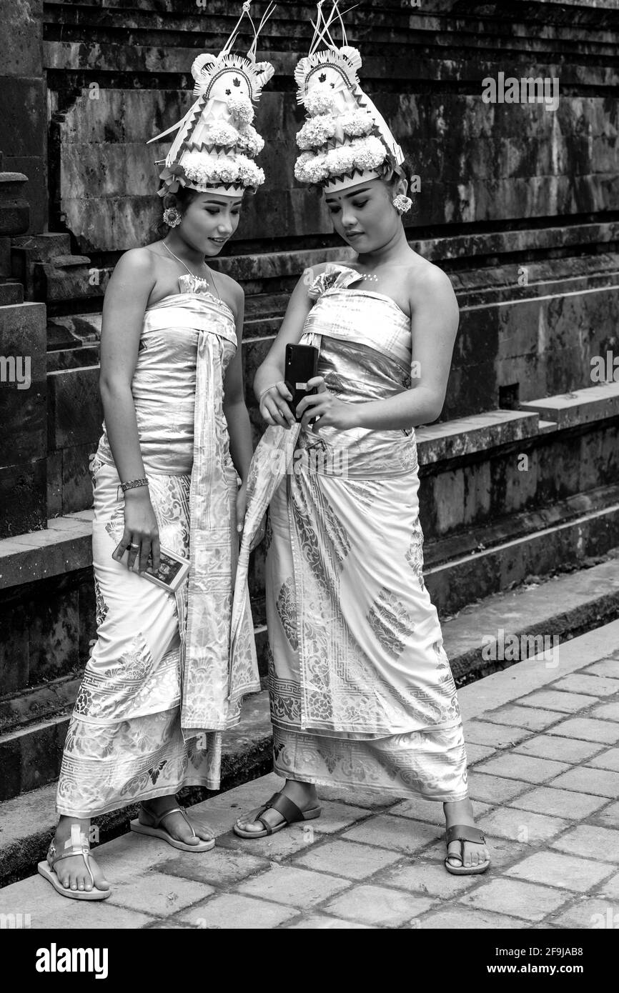 Two Young Balinese Hindu Females Looking At A Mobile Phone (Cell Phone ...