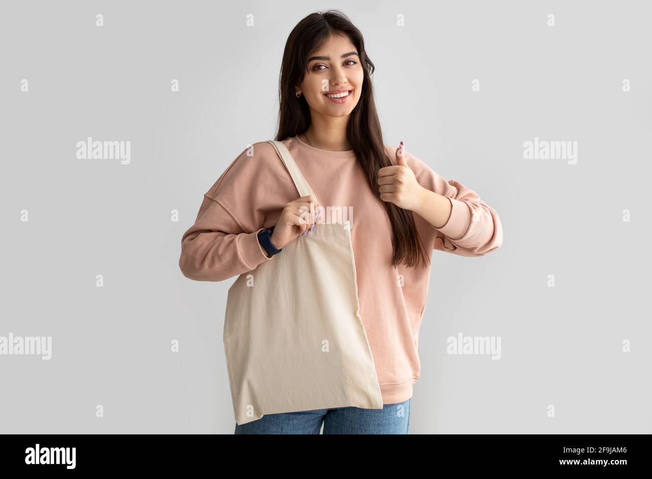 Woman standing with blank canvas tote bag showing thumb up Stock Photo ...