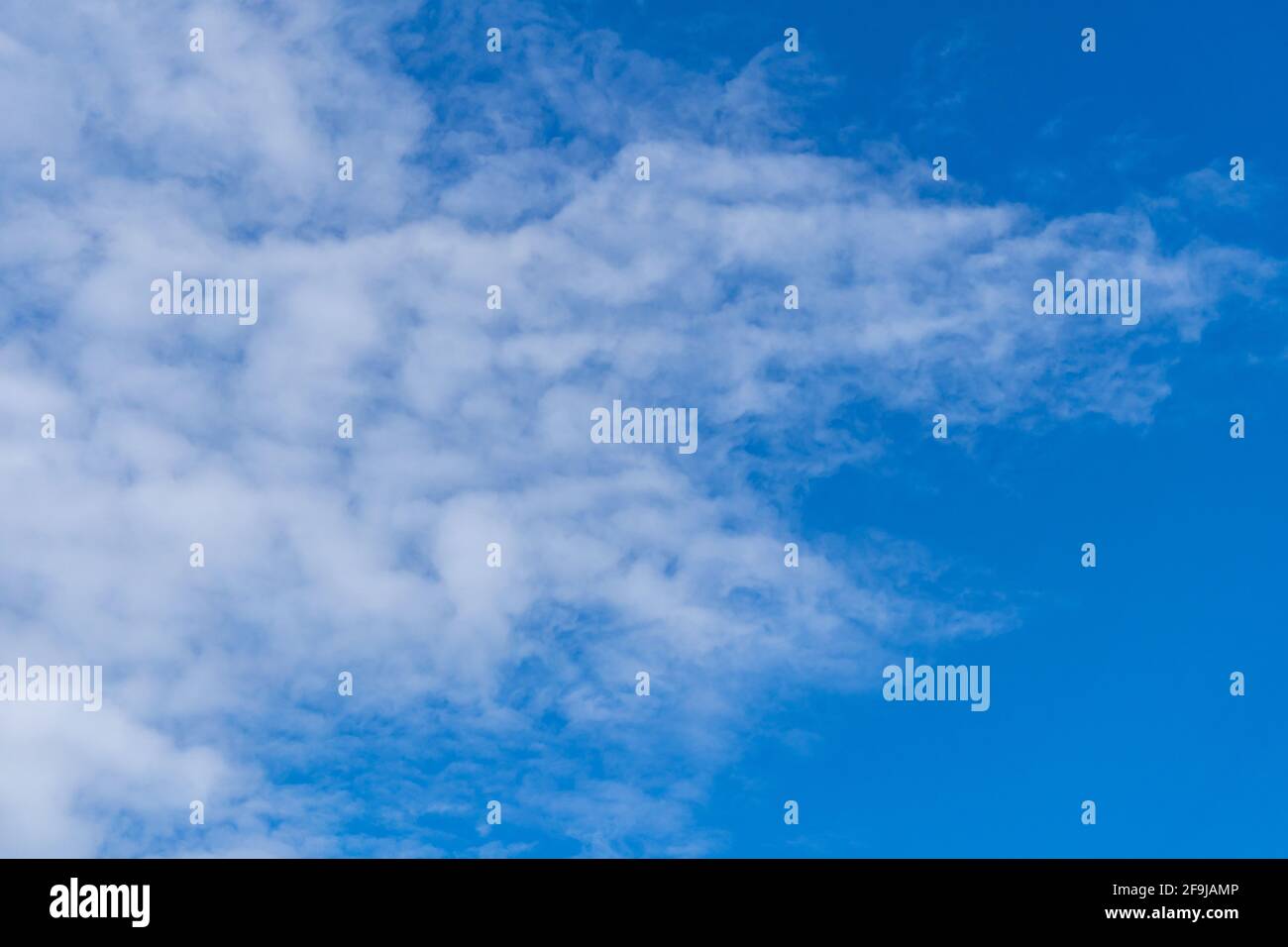 Wispy cloud floating on blue sky background Stock Photo - Alamy