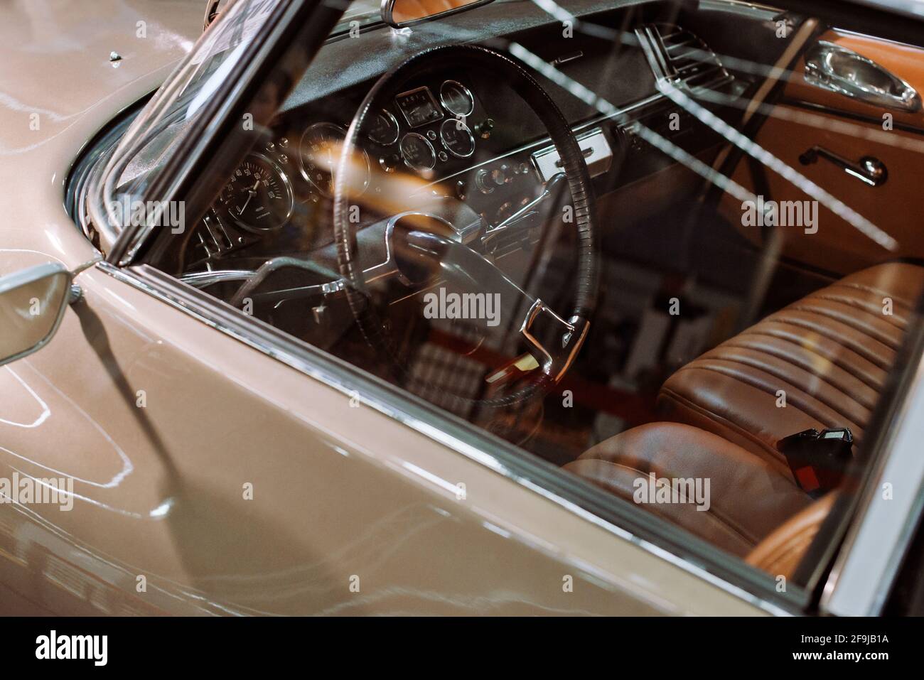 Interior of a beige classic car with leather seats at a car show or ...