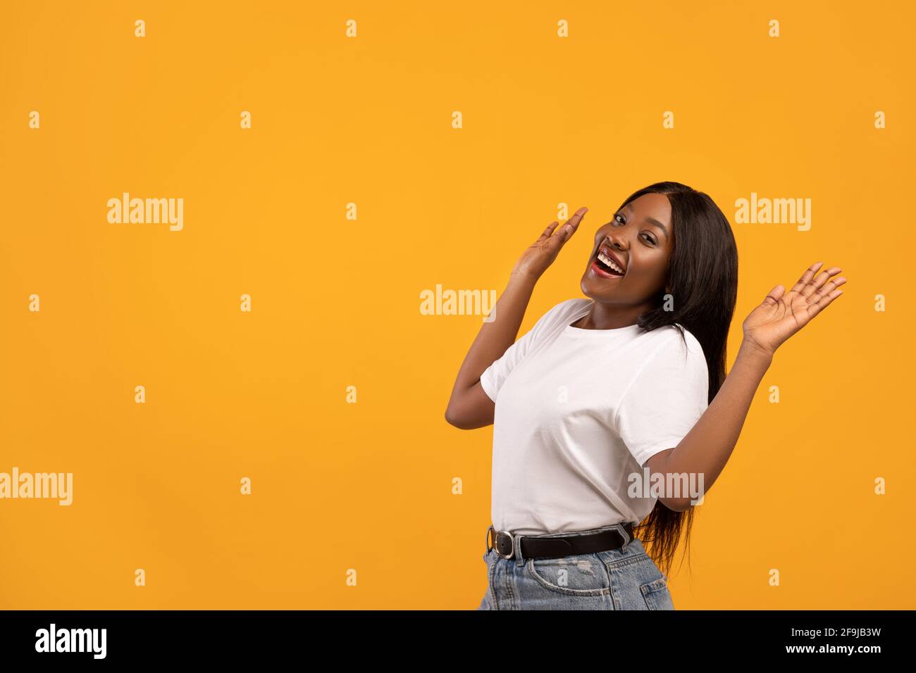 Excited black woman raising hands up towards copy space Stock Photo - Alamy