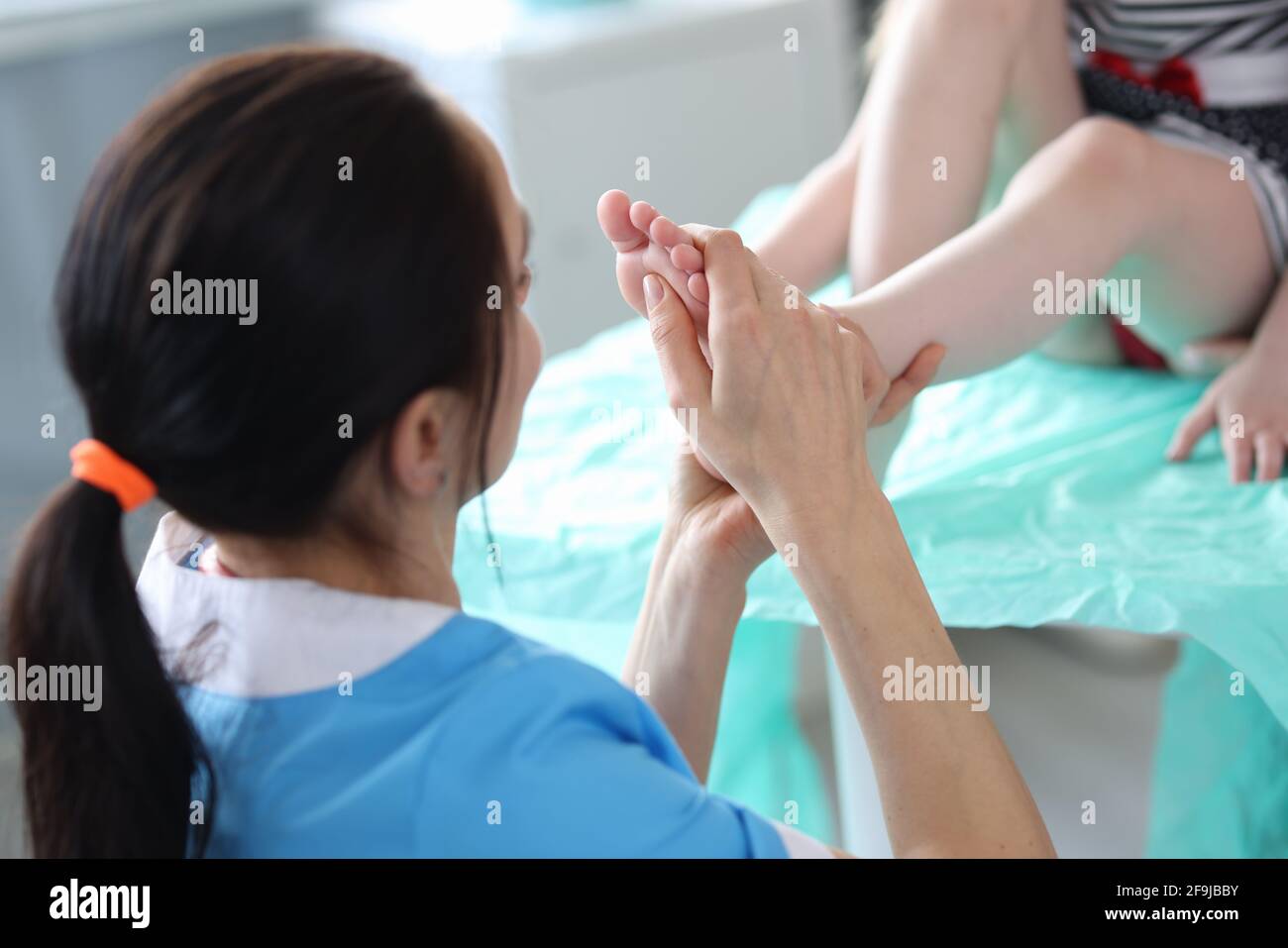 Doctor examining feet of little girl in clinic closeup Stock Photo - Alamy