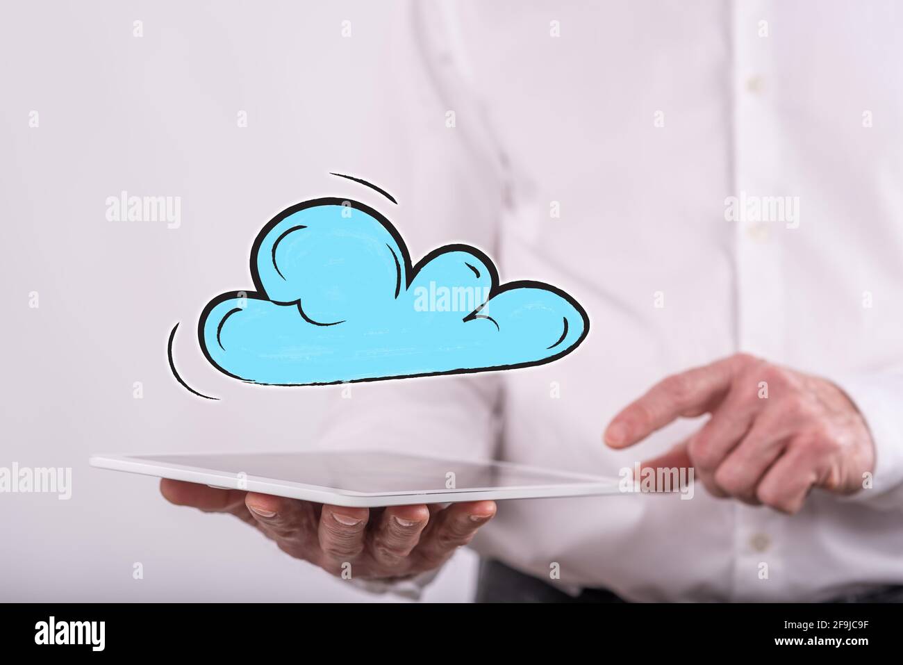 Cloud networking concept above a tablet held by a man in background ...