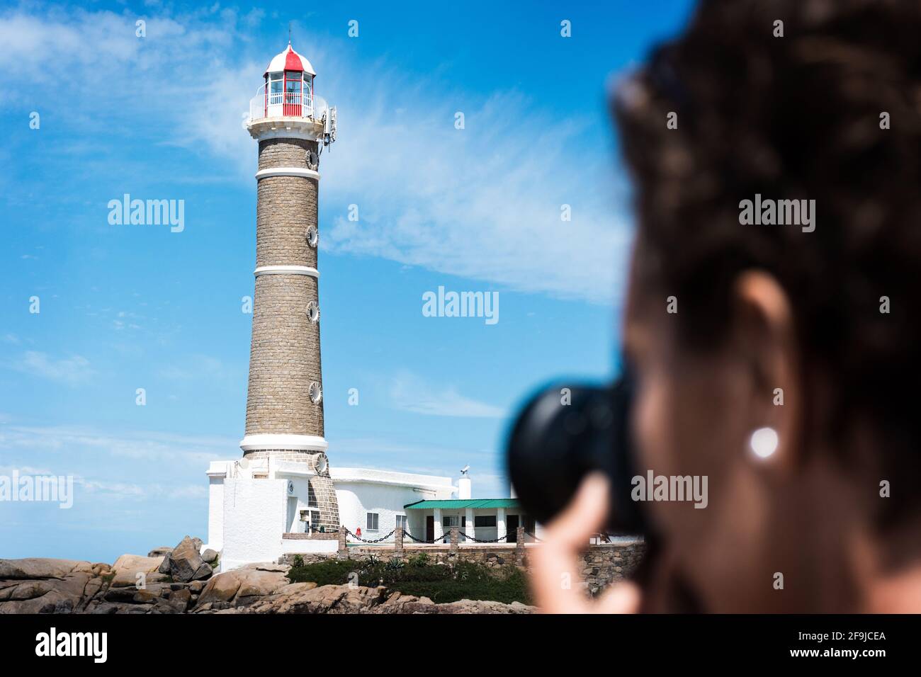 Closeup view of a person photographing a lighthouse in Cabo Polonio ...