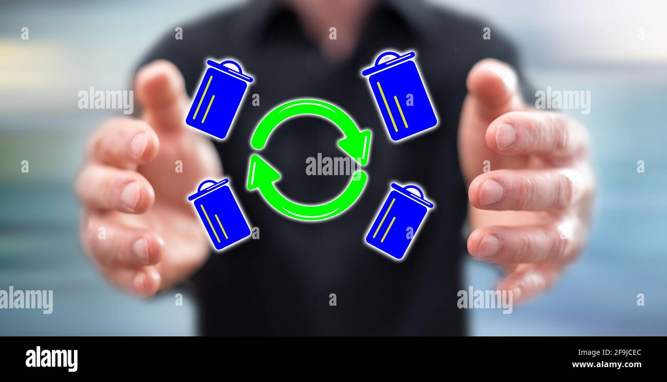 Recycling concept between hands of a man in background Stock Photo - Alamy